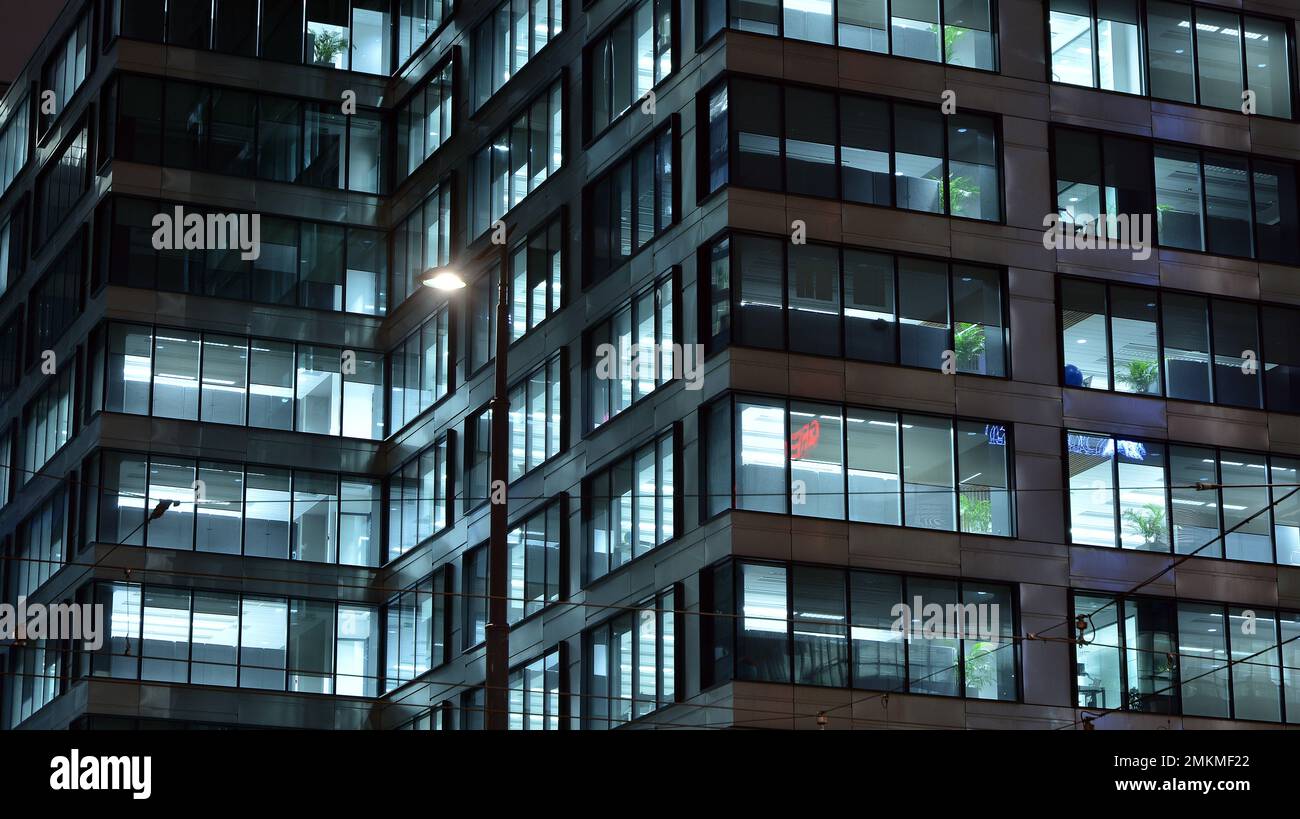 Pattern of office buildings windows illuminated at night. Glass ...