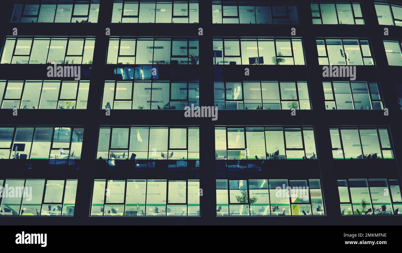 Pattern of office buildings windows illuminated at night. Glass ...