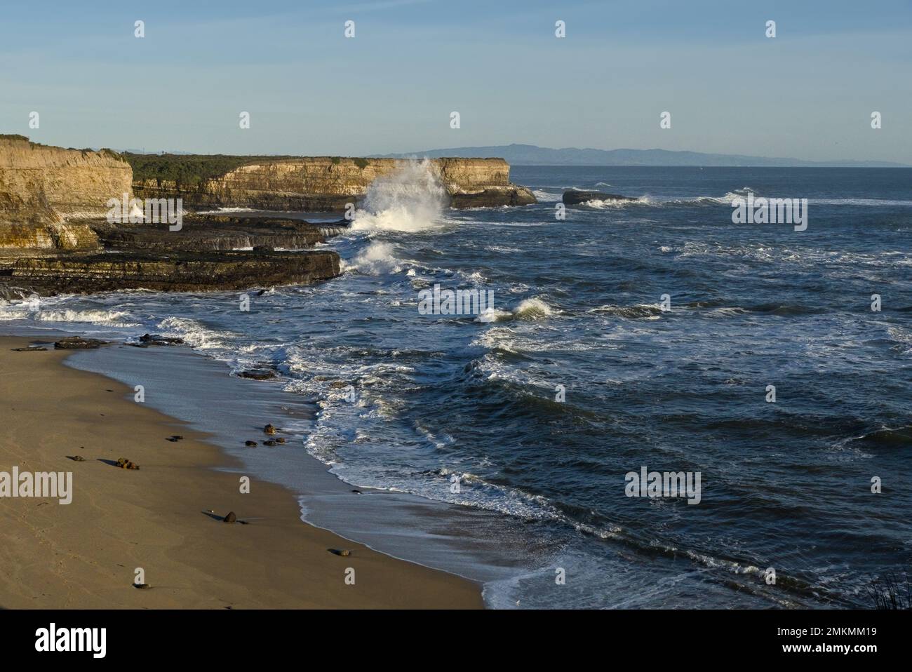 Santa Cruz coast line with cliffs and rocks. There're small waves on ...