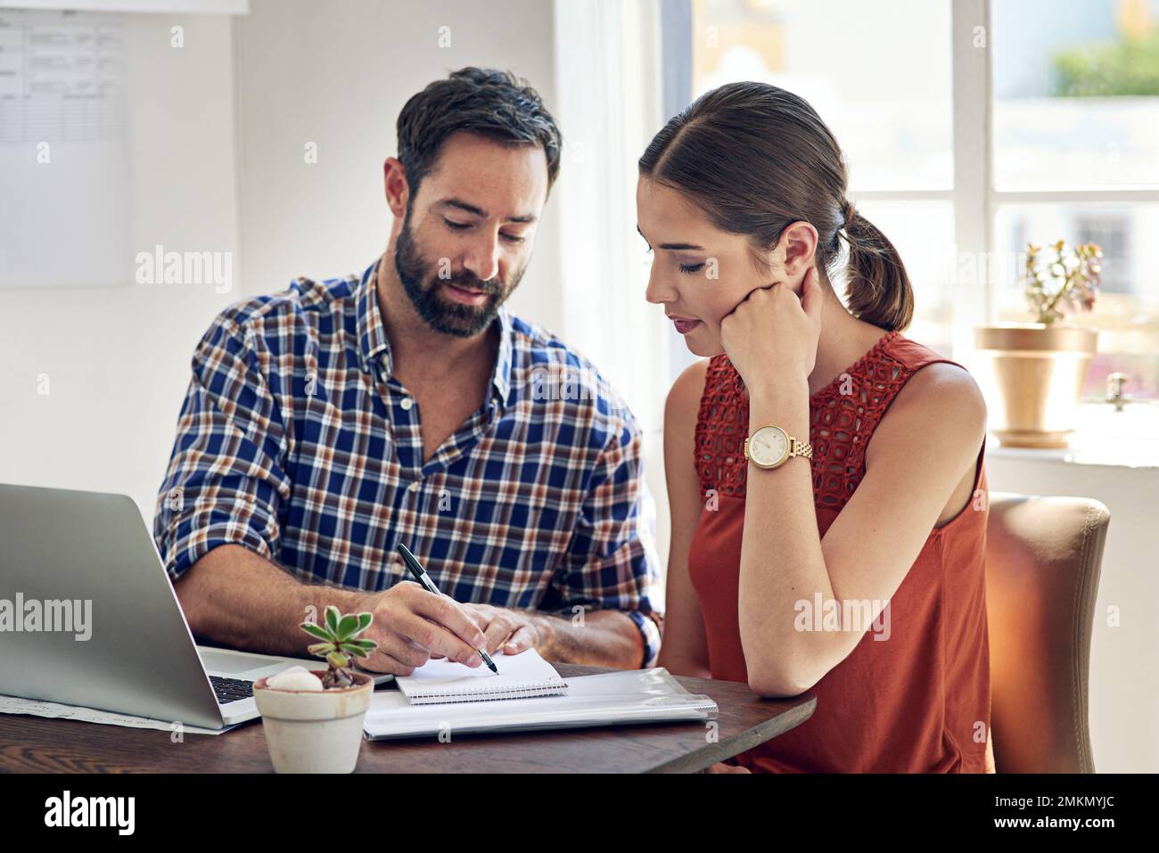 Putting his ideas on paper. a two colleagues working together at a desk ...