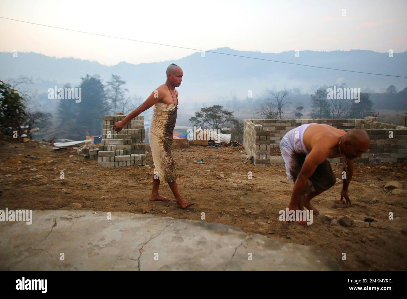 Nepalese Hindu devotees prostrate on the ground outside a temple as a ...