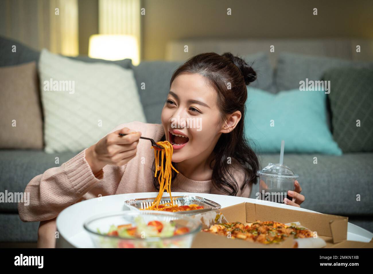 The young lady at home eating take-away Stock Photo - Alamy