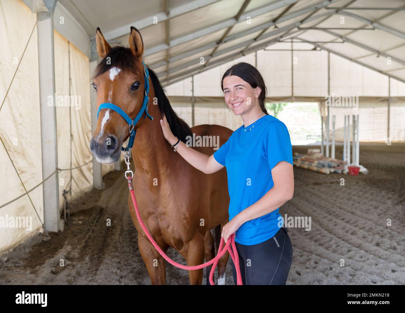 Cheerful young female with dark hair looking at camera with smile and ...
