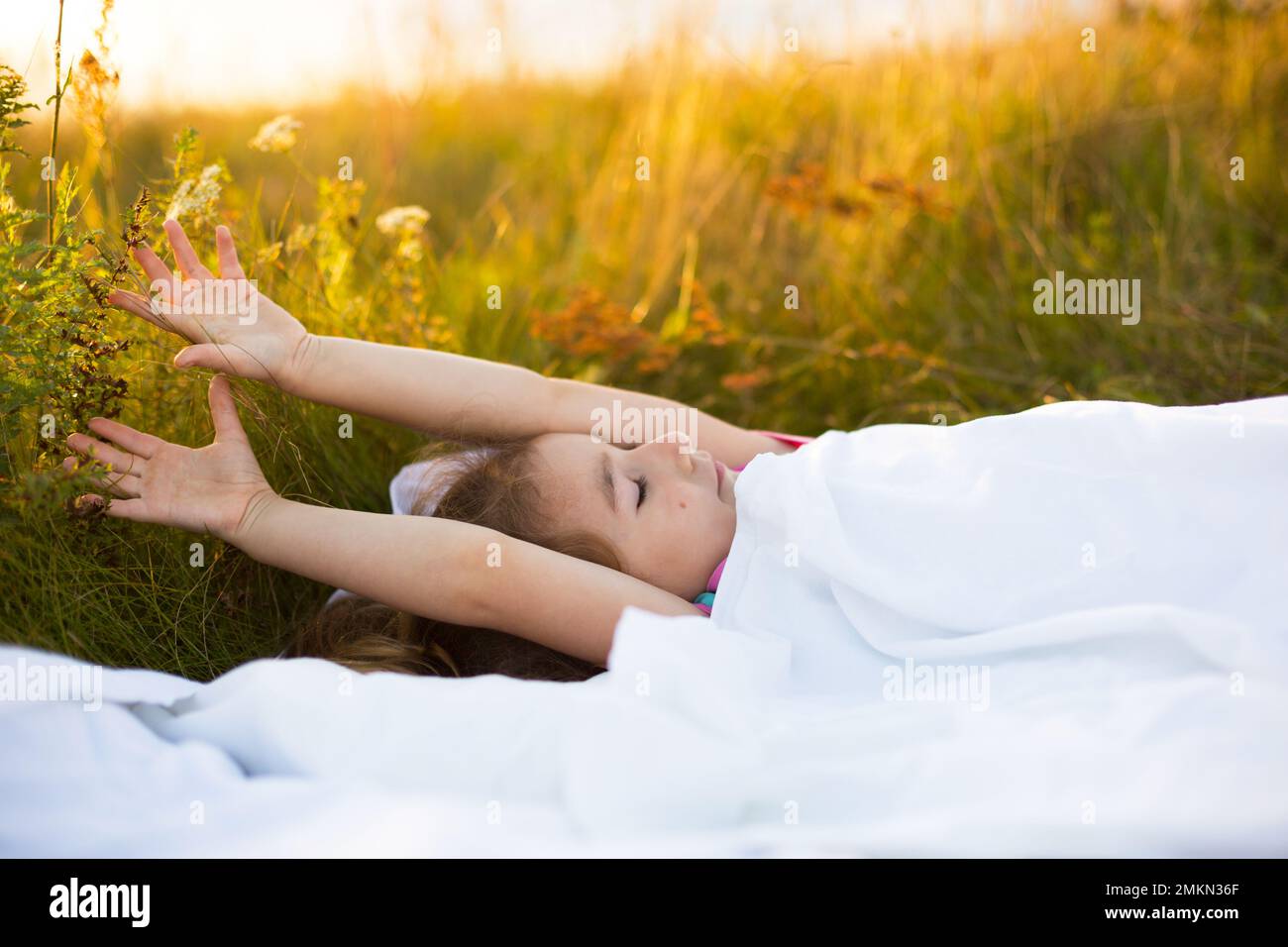 Girl sleeps on bed in grass, Sweet stretches and yawns sleepily, good ...
