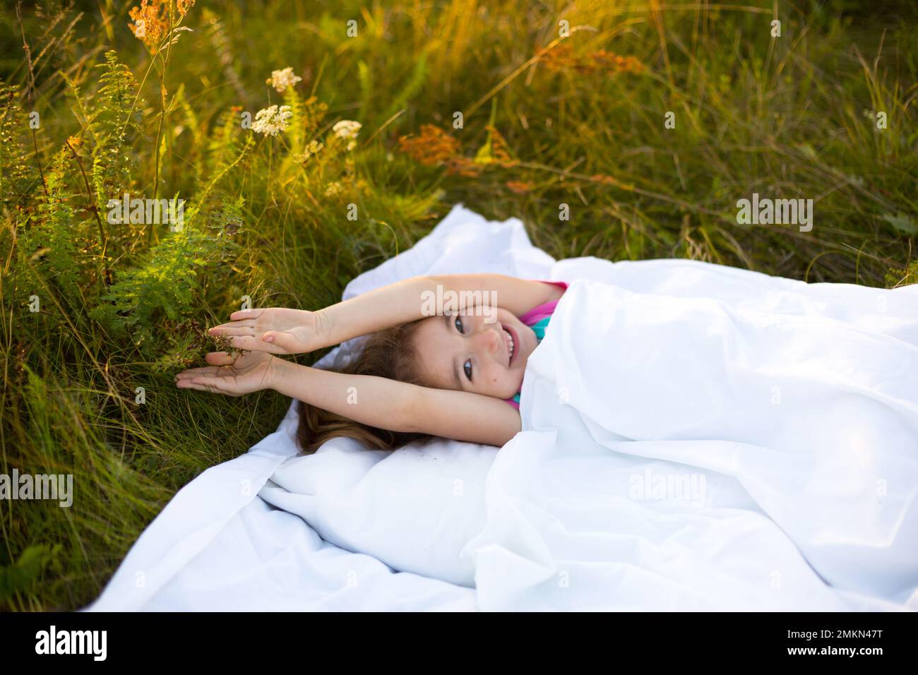 Girl sleeps on bed in grass, Sweet stretches and yawns sleepily, good ...