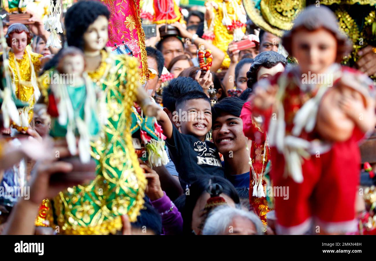 Roman Catholic devotees raise images of the Child Jesus, known as Santo ...