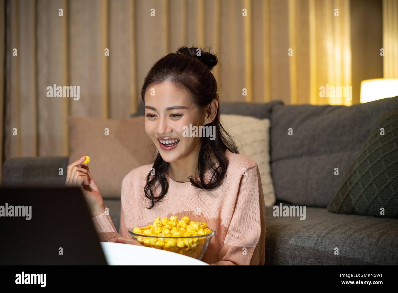 The young lady eat at home use the computer Stock Photo - Alamy