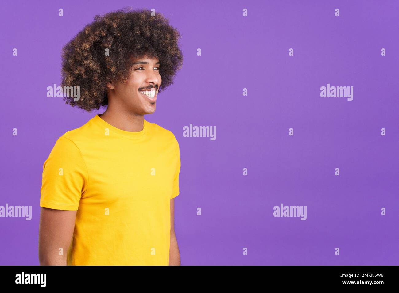African man smiling while looking aside and standing Stock Photo - Alamy