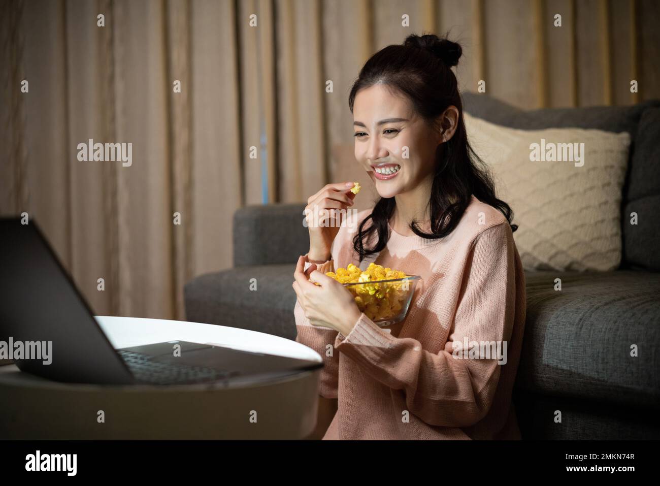 The young lady eat at home use the computer Stock Photo - Alamy