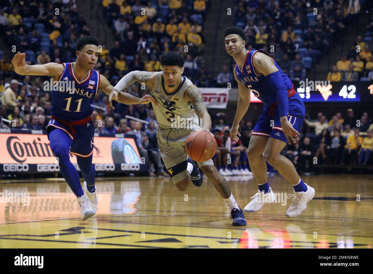 West Virginia guard James Bolden (3) drives past Kansas guard Devon ...