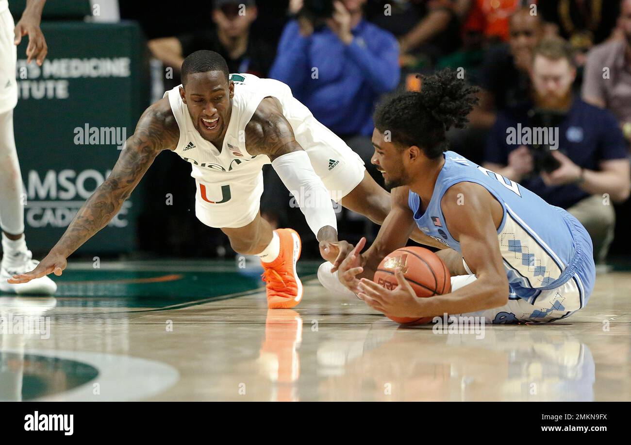 Miami guard Zach Johnson, left, dives for the ball against North ...
