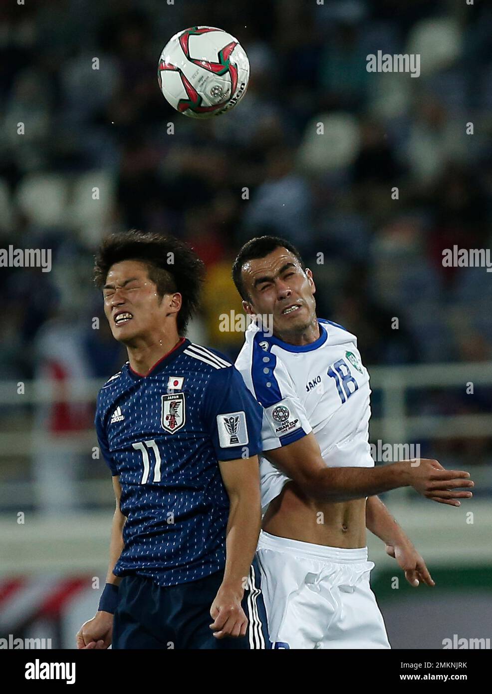 Japan's forward Koya Kitagawa, left, jumps for the ball with Uzbekistan ...