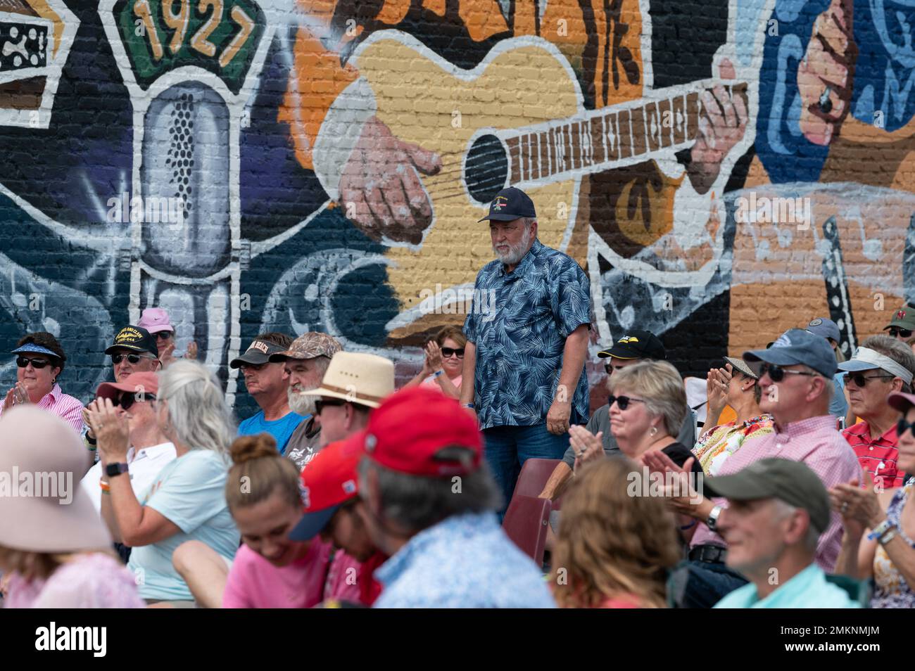 A veteran stands to be recognized as the U.S. Navy Band Country Current ...
