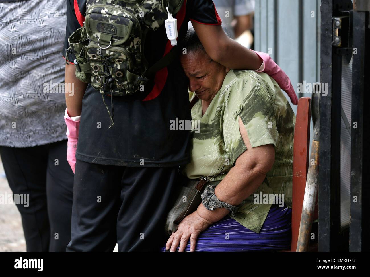 Maria Cruz, 80, is comforted by her grandson Johnny Medina as she cries ...