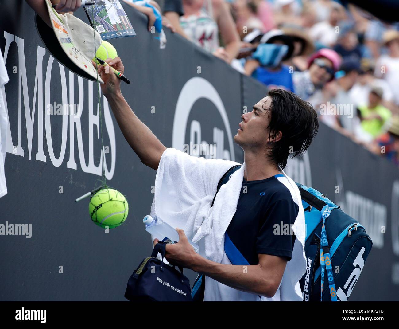 Japan's Taro Daniel signs autographs after his first round win over ...