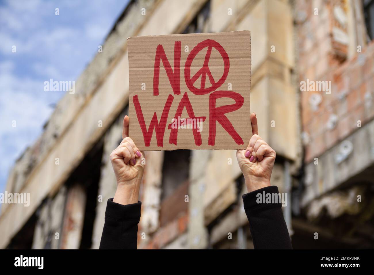 Woman holding No War placard with peace sign in protest against war ...
