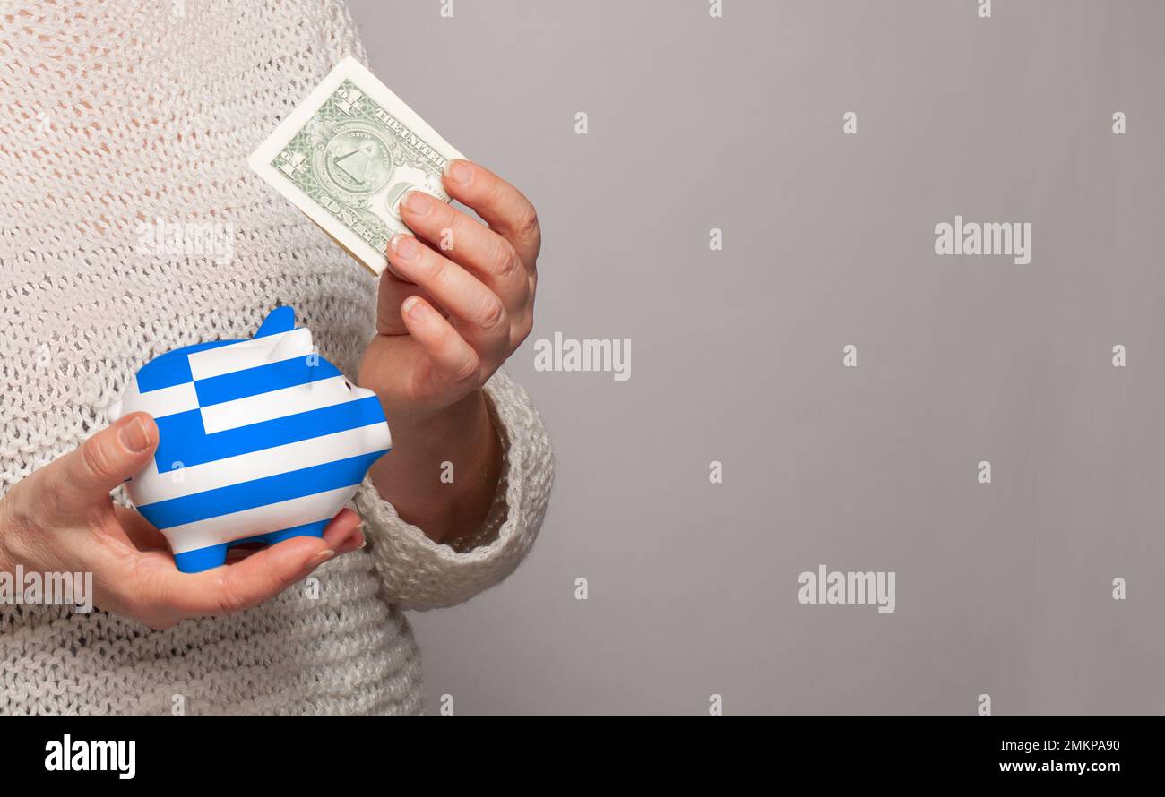 Flag of Greece on money bank in Greek woman hands. Dotations, pension ...