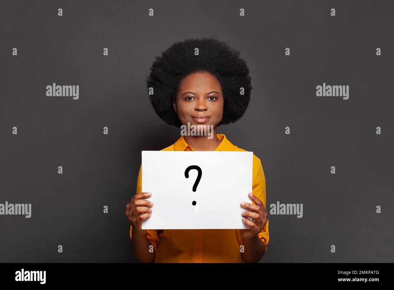 Cheerful african american woman showing card with question mark on ...