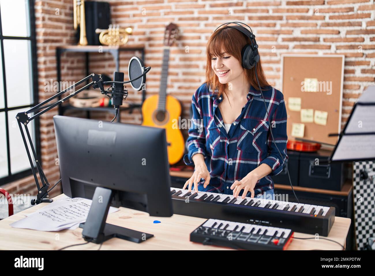 Young woman musician playing piano keyboard at music studio Stock Photo ...