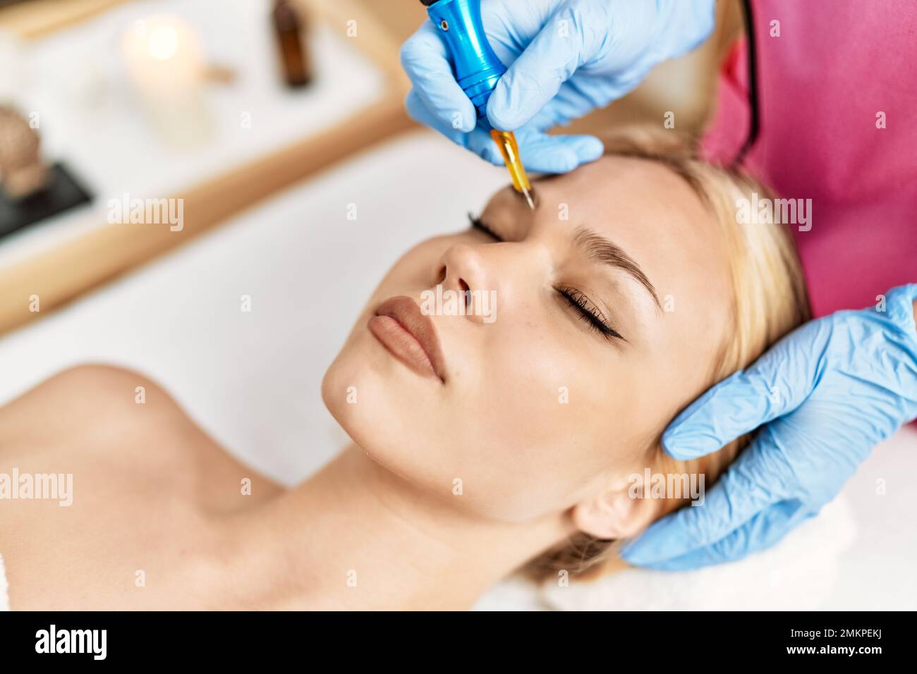 Young caucasian woman lying on table having microblading treatment at ...