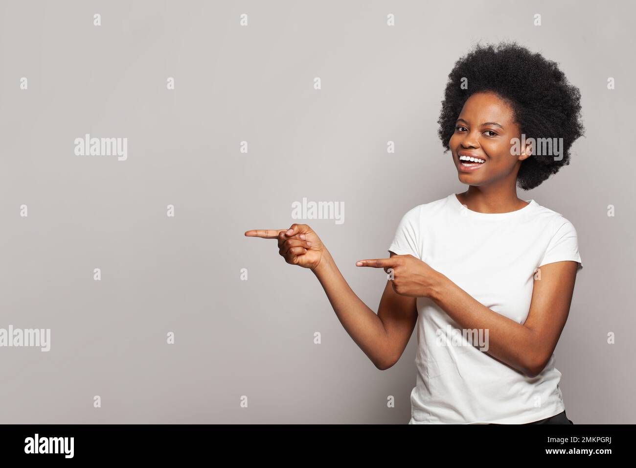 Joyful surprised woman pointing finger left copy space on white ...