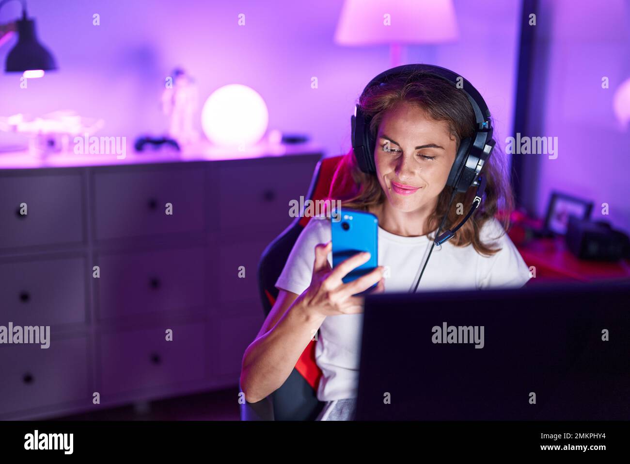 Young beautiful hispanic woman streamer using computer and smartphone ...
