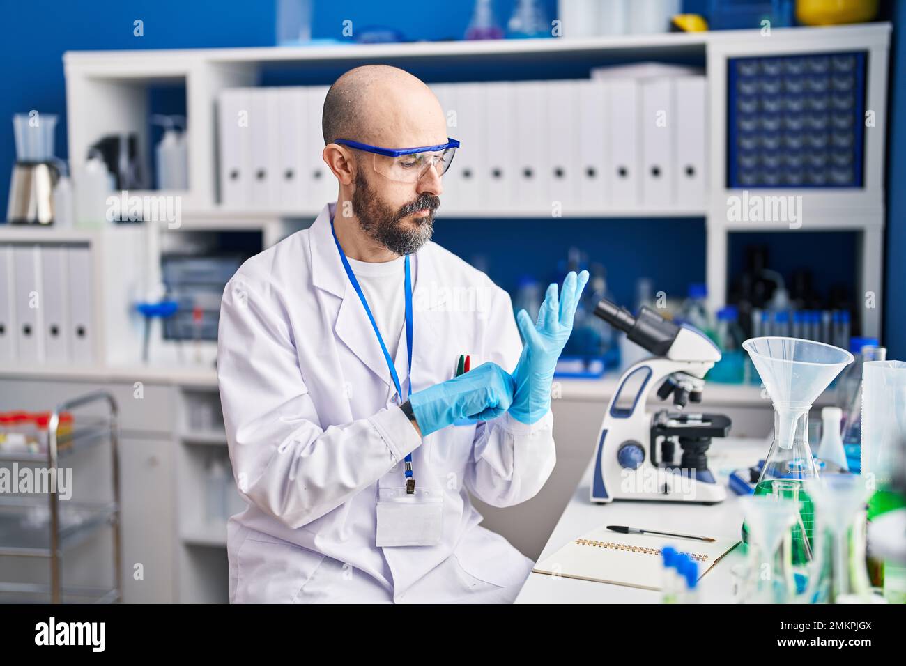 Young bald man scientist wearing gloves at laboratory Stock Photo - Alamy