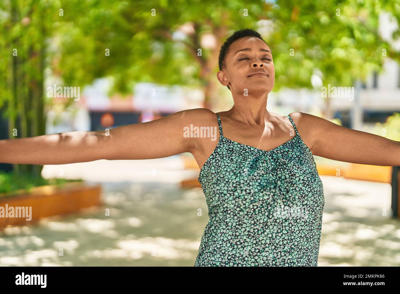 African american woman breathing with arms open at park Stock Photo - Alamy