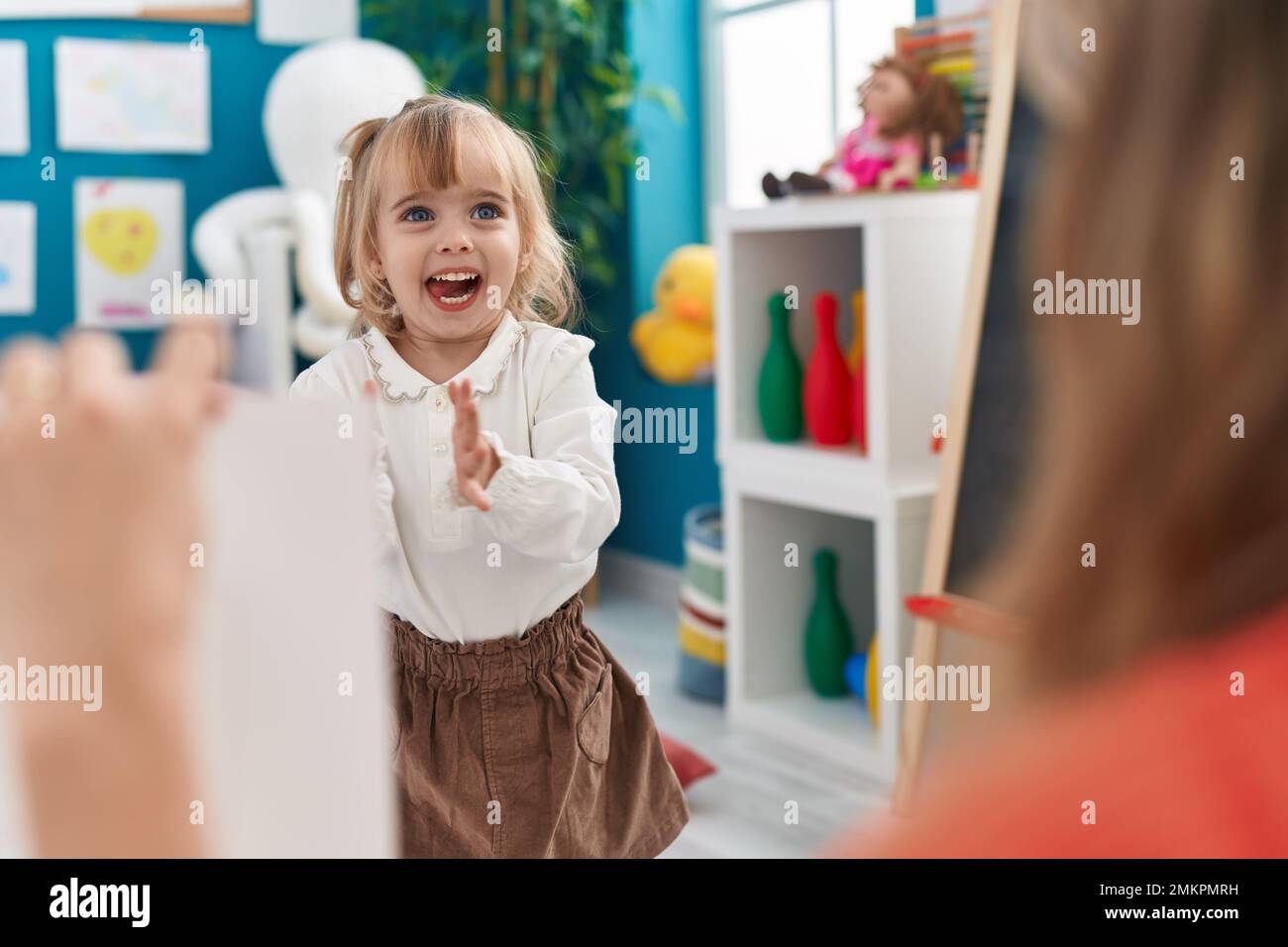 Adorable blonde girl smiling confident clapping hands at kindergarten Stock Photo - Alamy