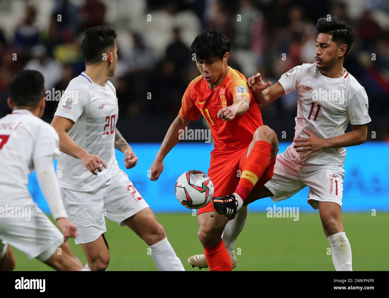 China's defender Hao Junmin, center, fights for the ball with two Philippine players Javier ...