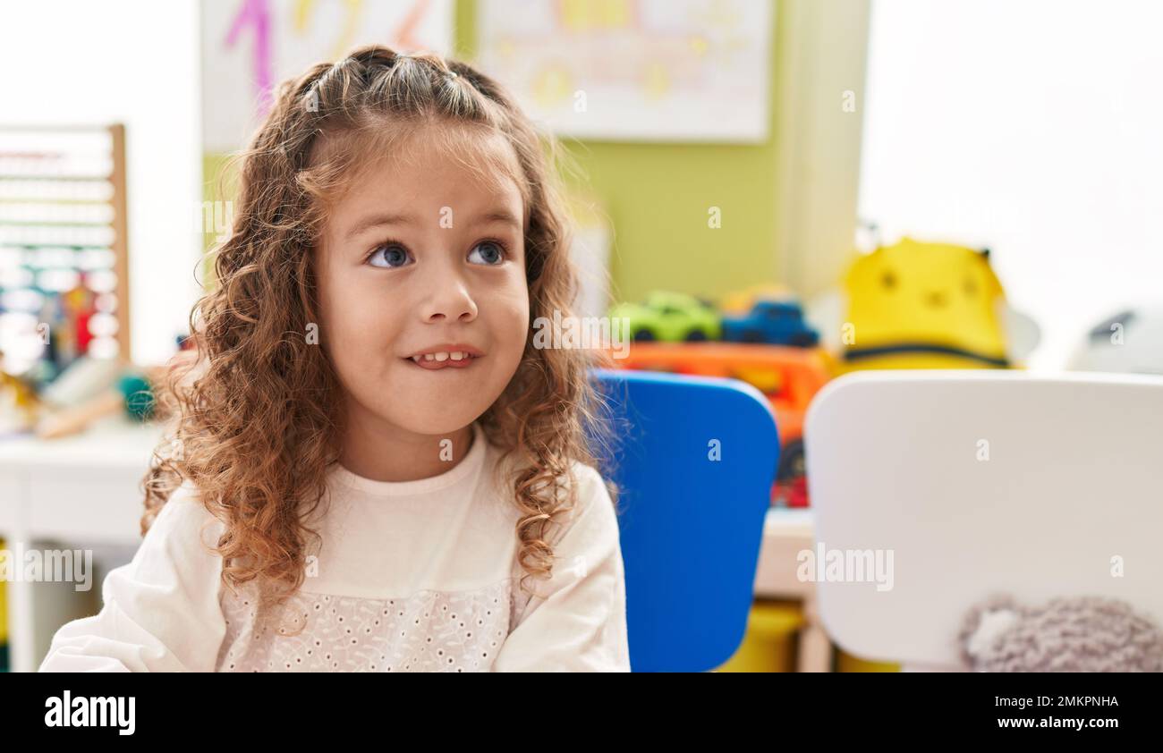 Adorable blonde toddler smiling confident sitting on chair at kindergarten Stock Photo - Alamy