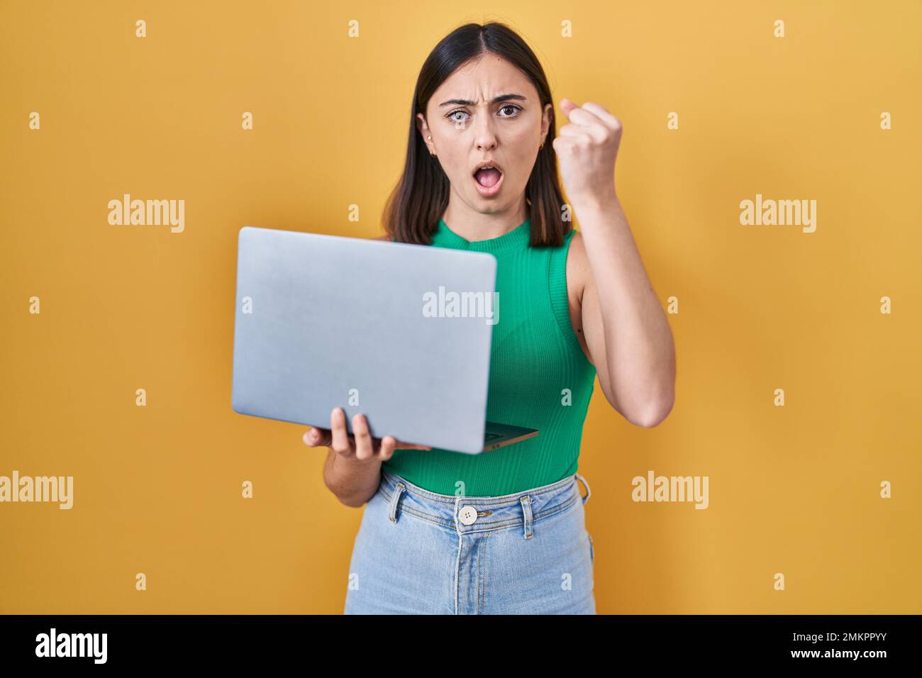 Hispanic girl working using computer laptop annoyed and frustrated ...
