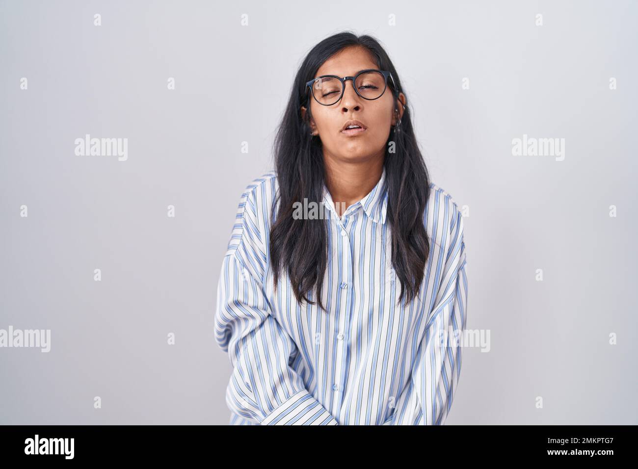 Young hispanic woman wearing glasses looking sleepy and tired ...