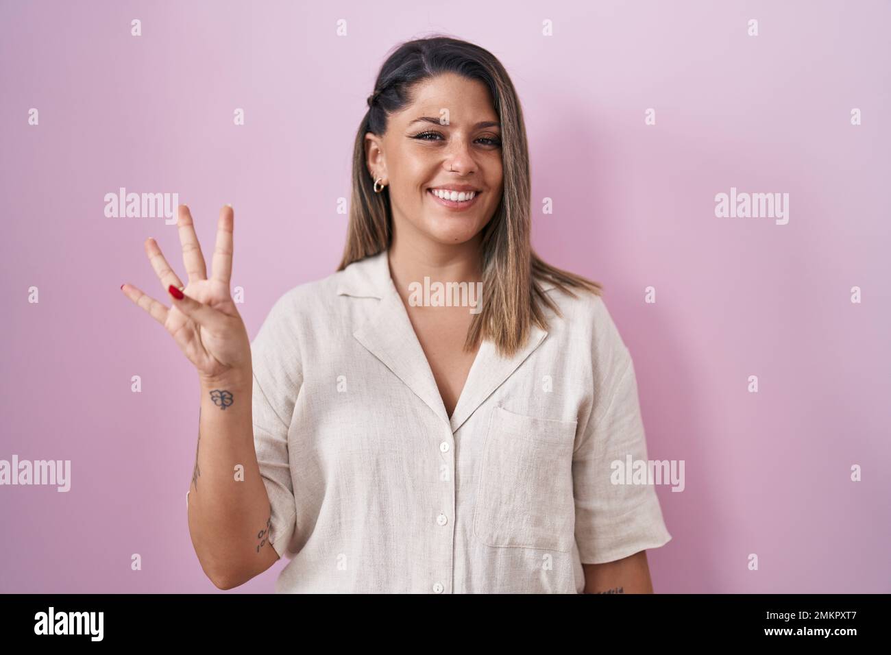 Blonde woman standing over pink background showing and pointing up with ...