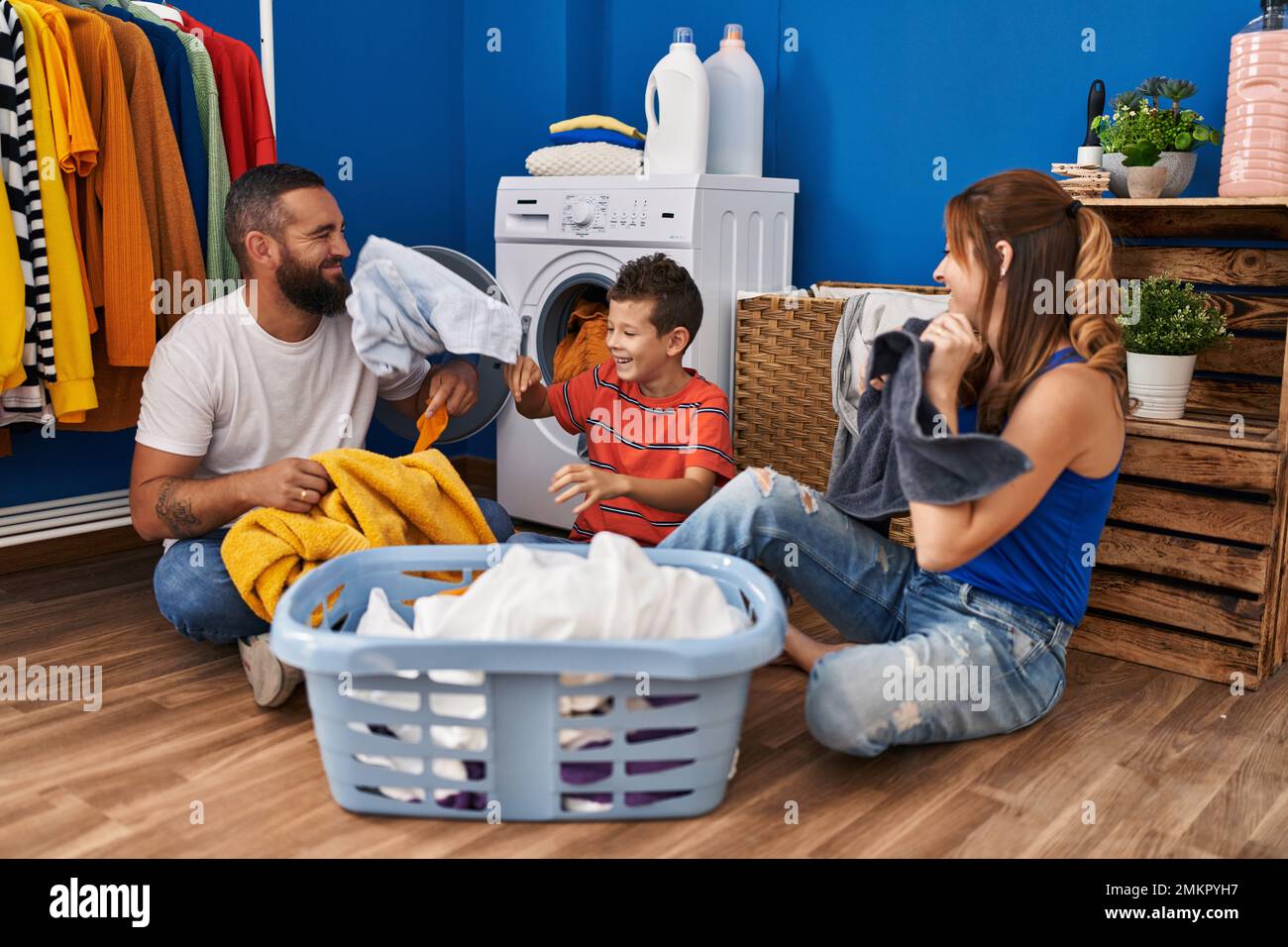 Family smiling confident playing with clothes at laundry room Stock ...