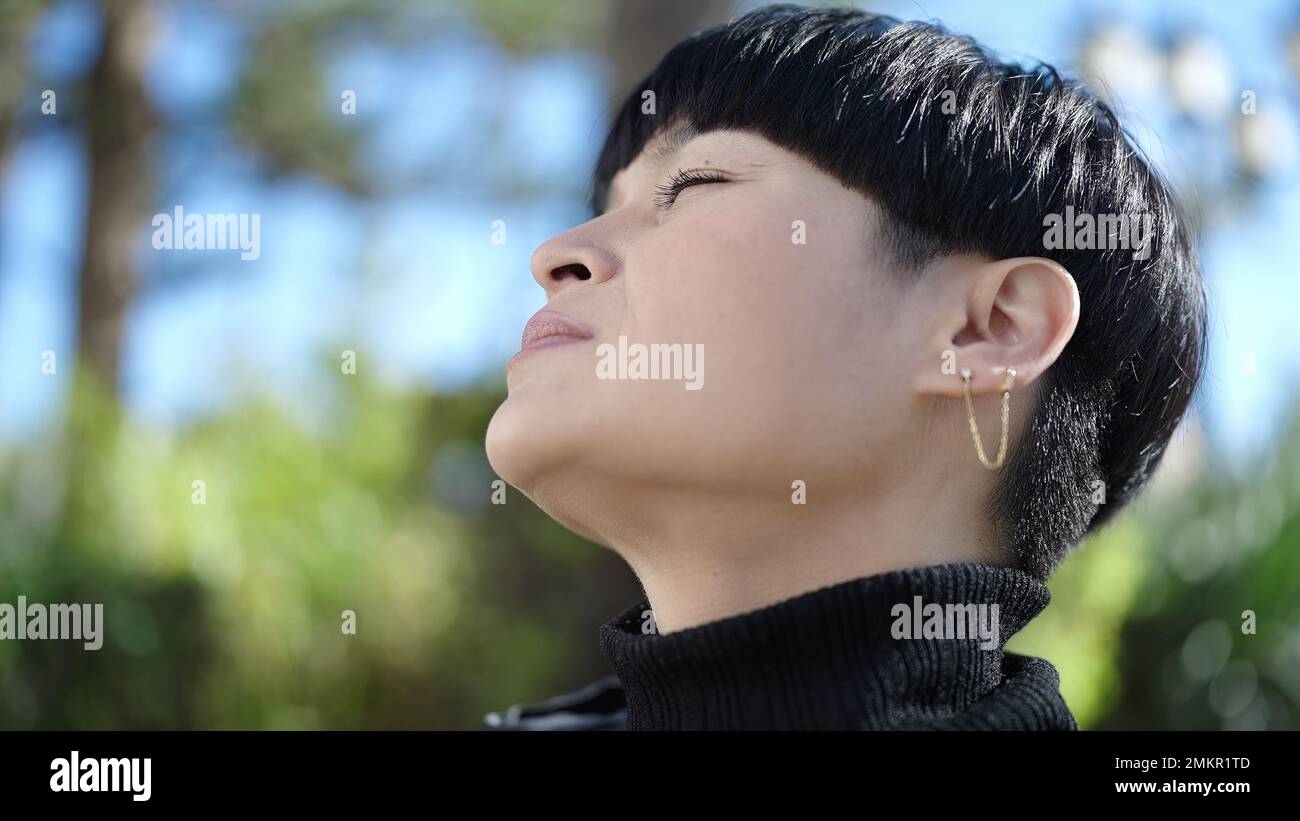 Young chinese woman breathing with closed eyes at park Stock Photo - Alamy