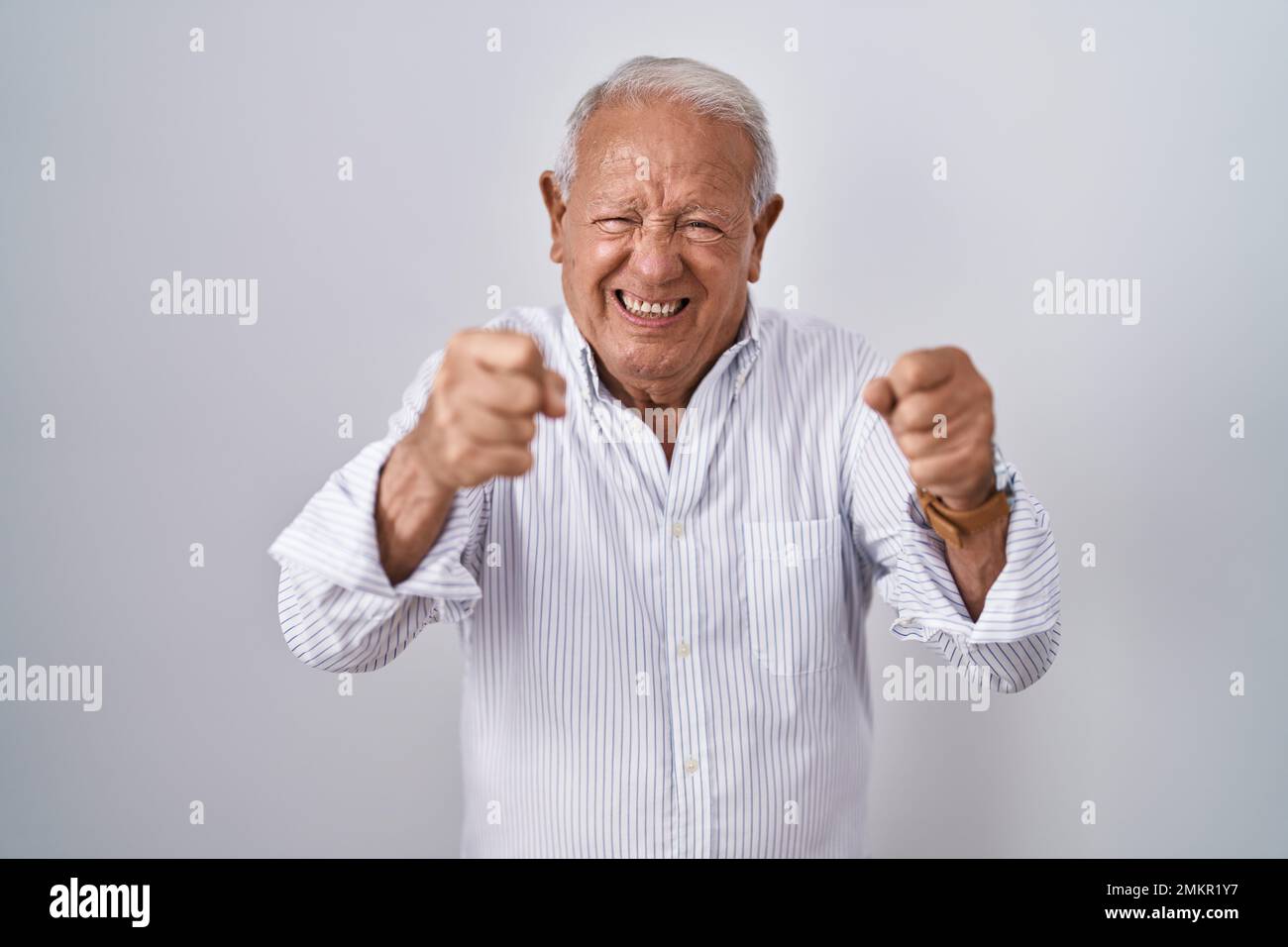 Senior man with grey hair standing over isolated background angry and ...