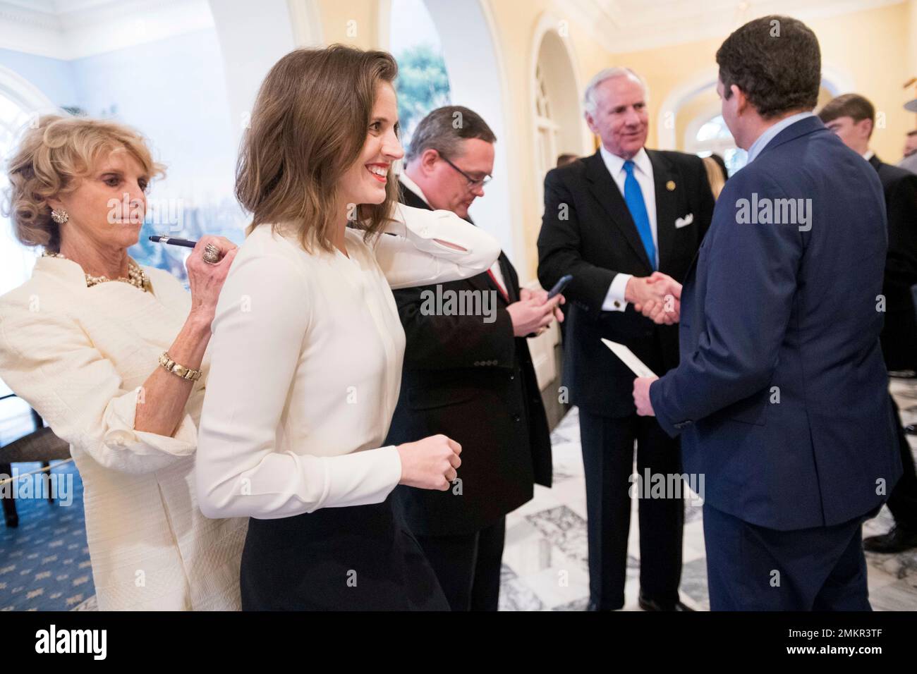 Peggy McMaster, left, signs an inauguration program with the help of ...