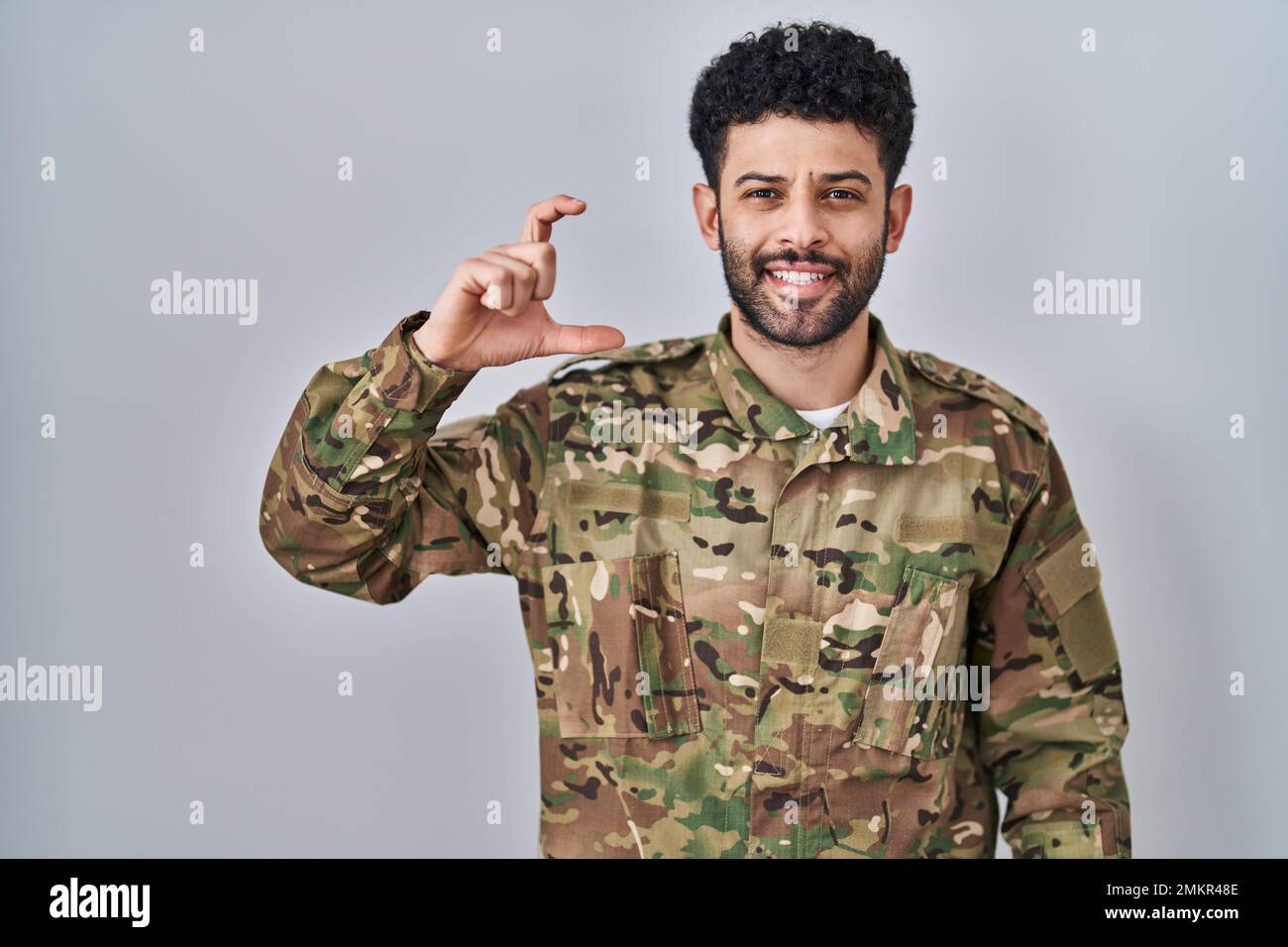 Arab man wearing camouflage army uniform smiling and confident ...