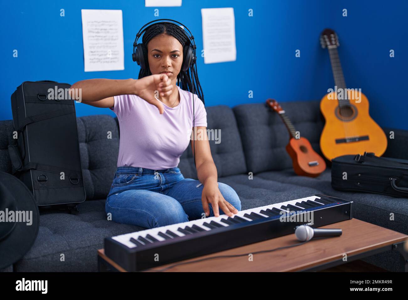 African american woman with braids playing piano keyboard at music ...
