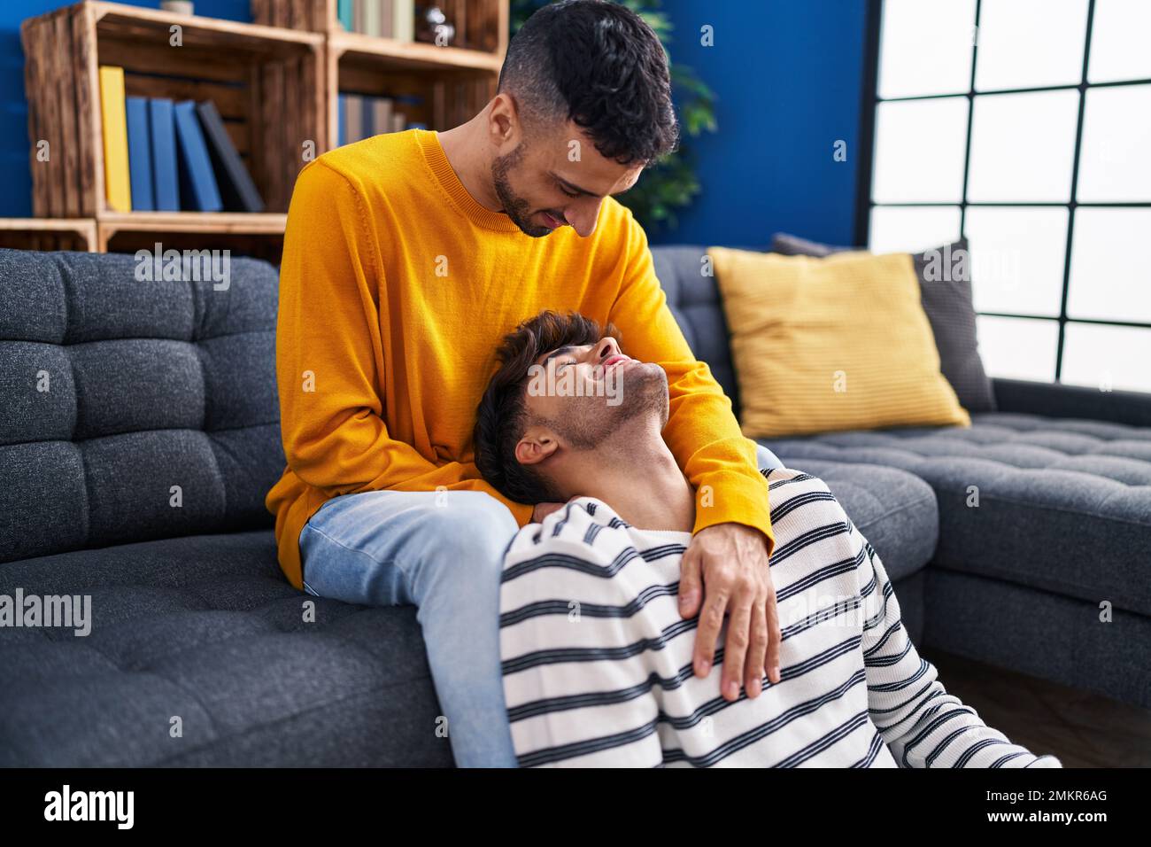Two man couple hugging each other sitting on sofa at home Stock Photo ...
