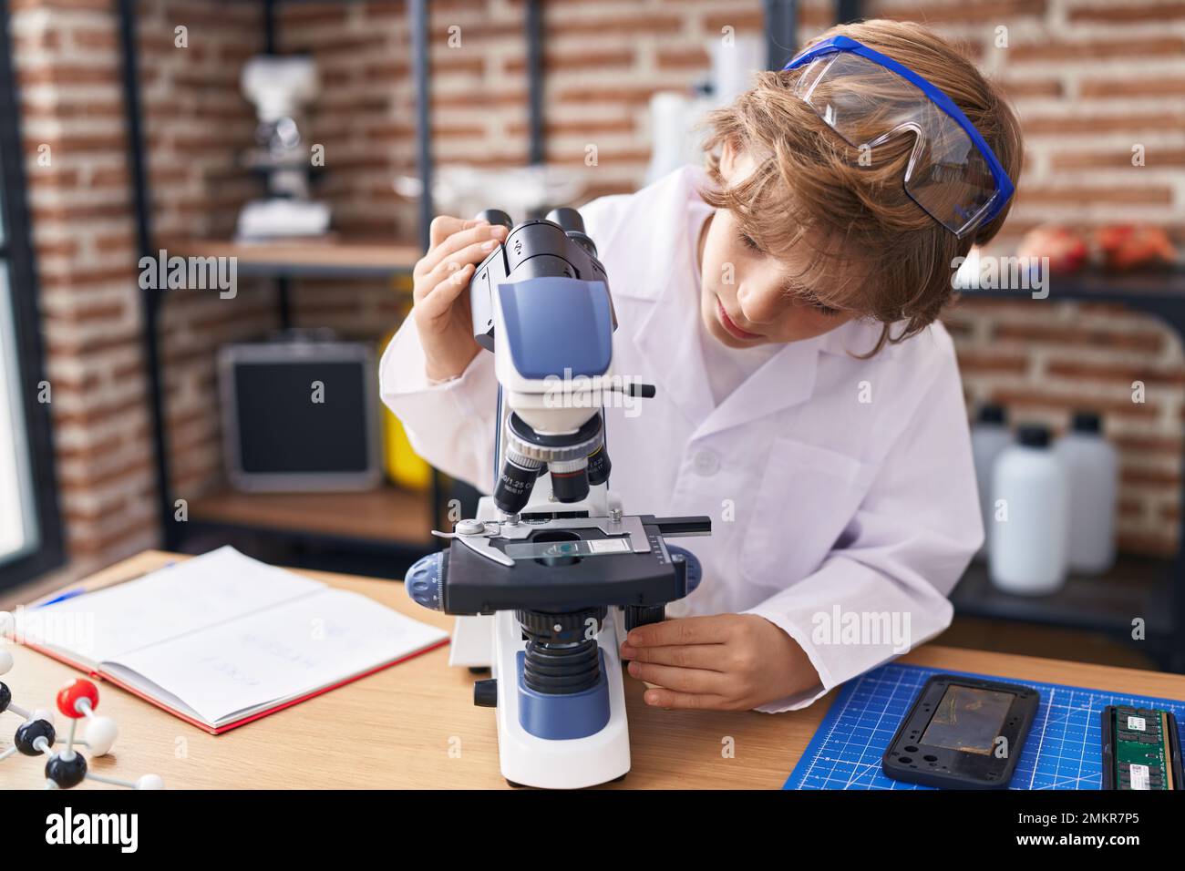 Adorable caucasian boy student using microscope at classroom Stock ...