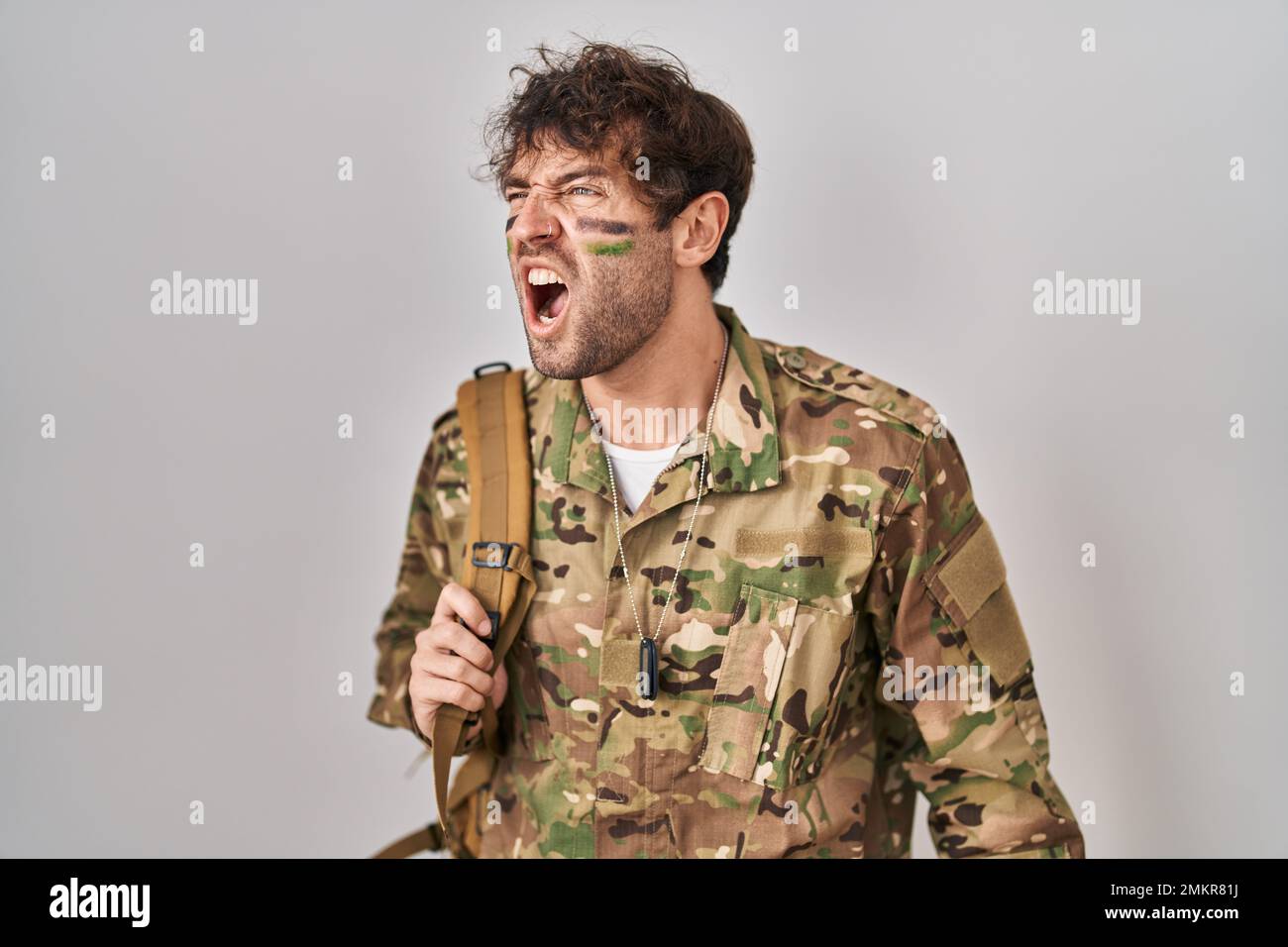 Hispanic young man wearing camouflage army uniform angry and mad ...