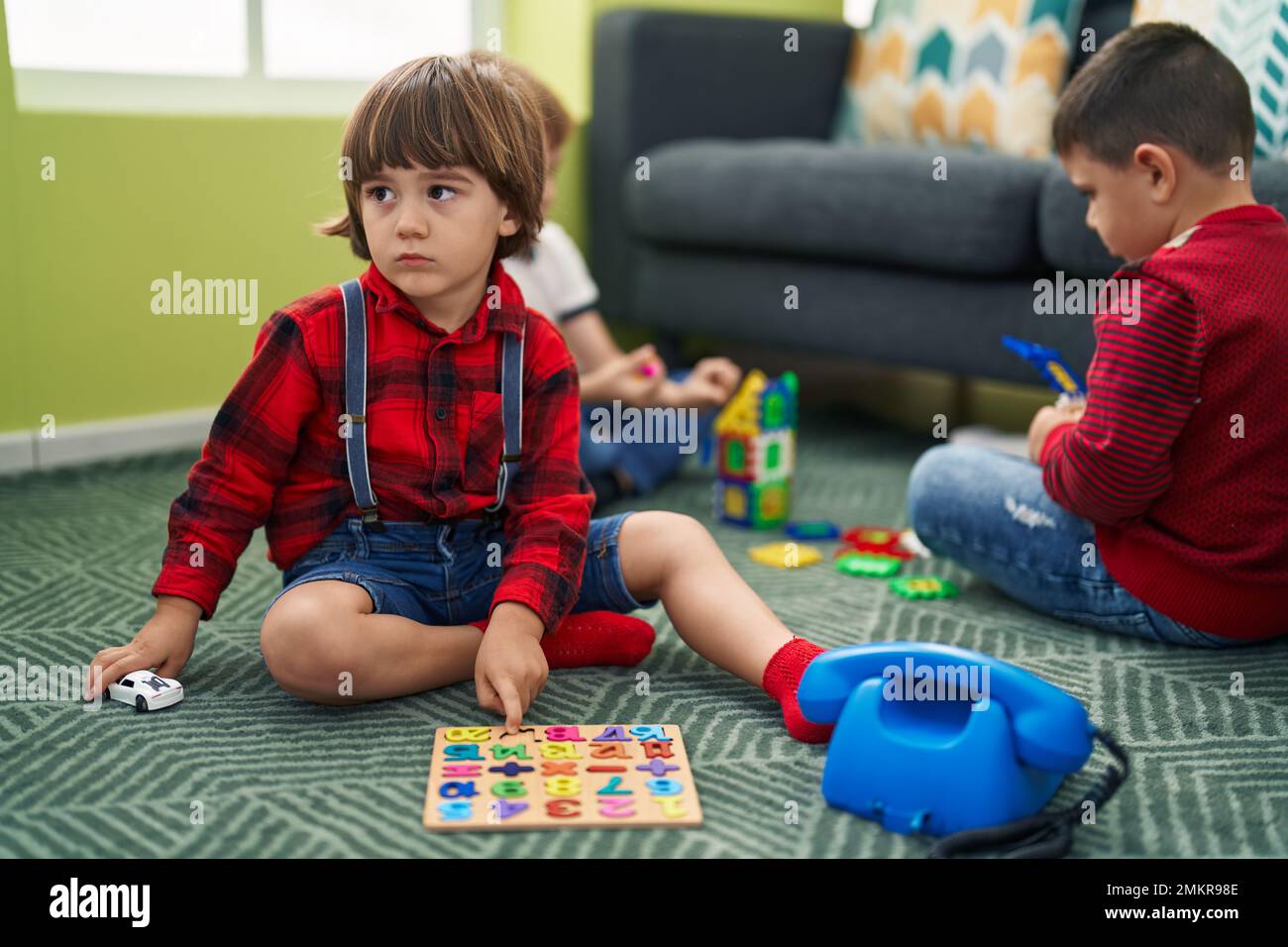 Two kids playing with maths puzzle game sitting on floor at home Stock ...