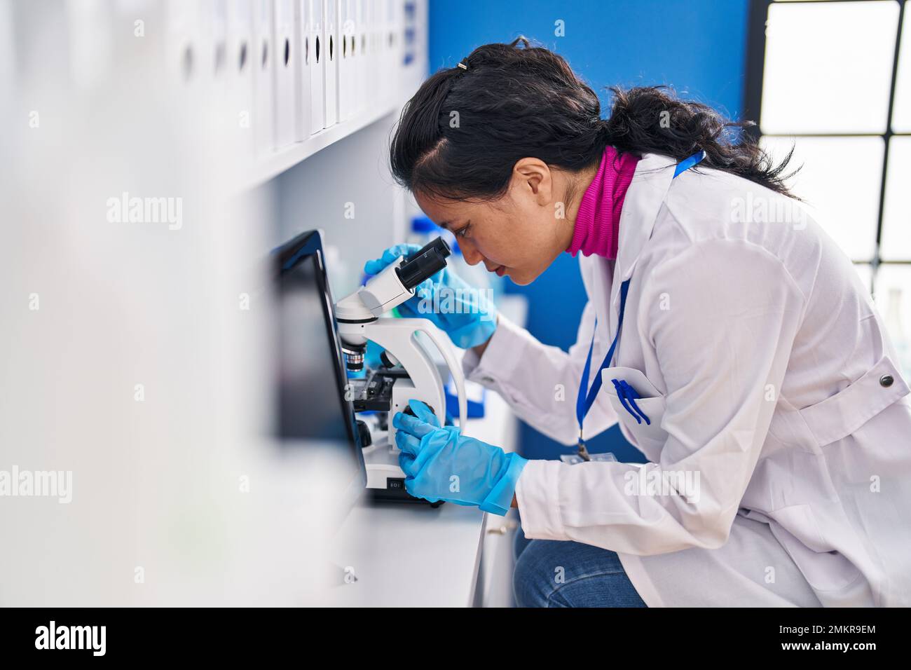 Young chinese woman scientist using microscope at laboratory Stock ...