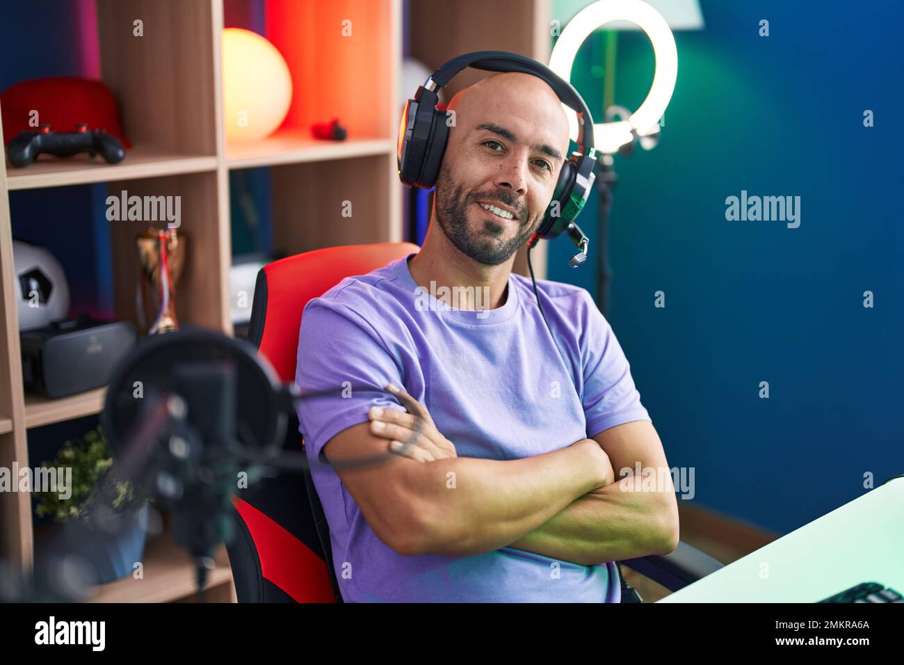 Young bald man streamer smiling confident sitting with arms crossed ...