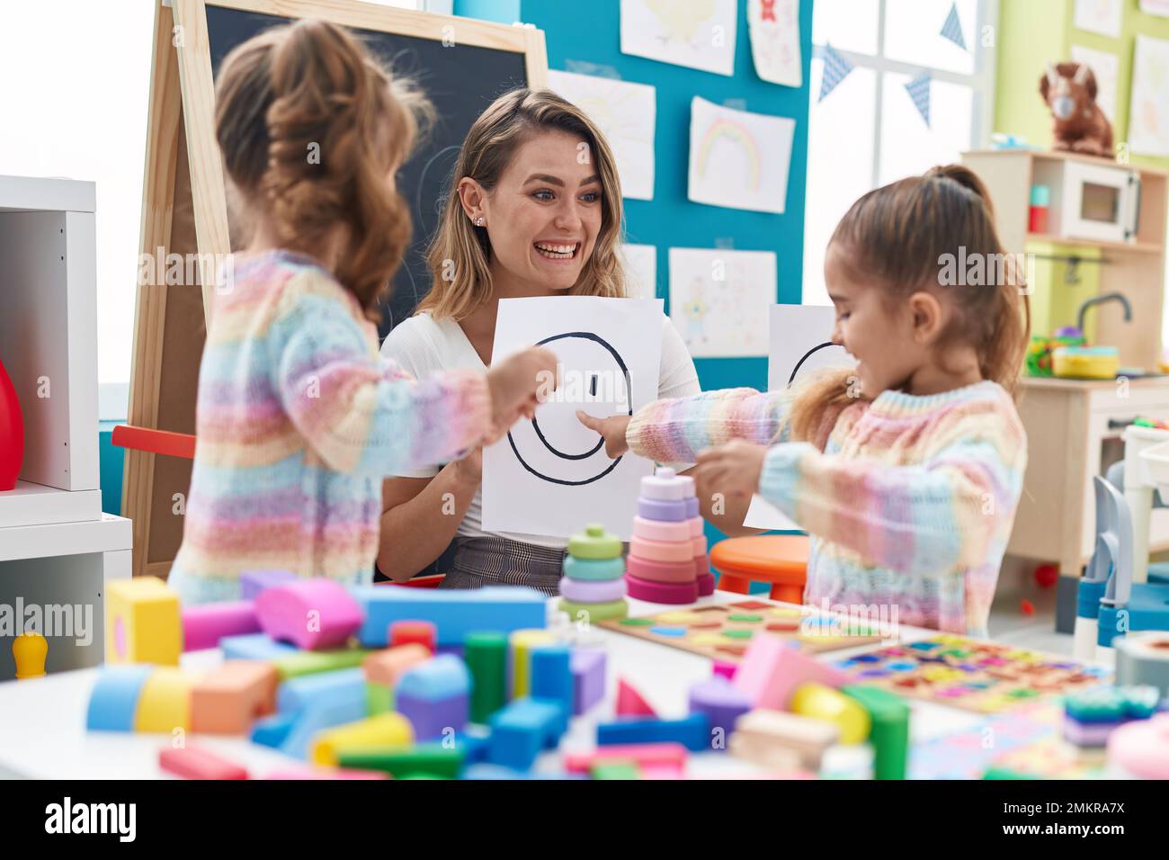 Teacher with girls sitting on table having emotion therapy at ...