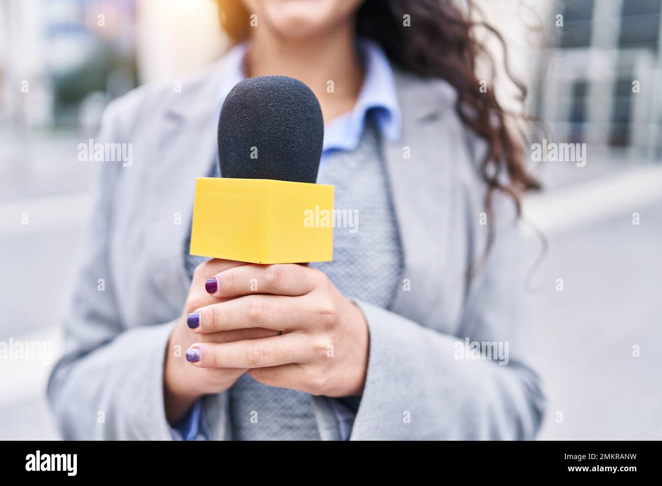 Young hispanic woman reporter working using microphone at street Stock ...
