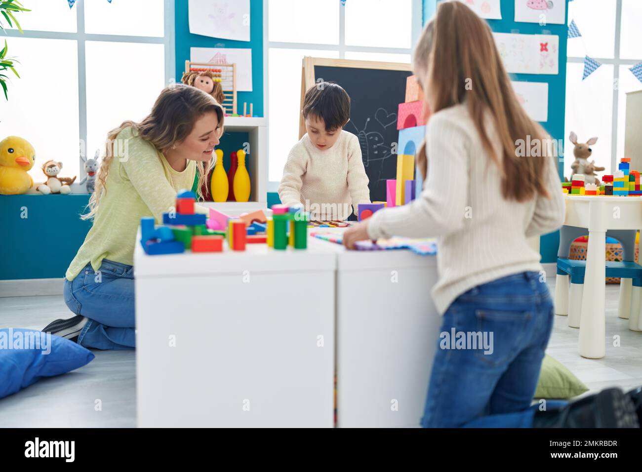 Group of kids playing with maths puzzle game with teacher at ...