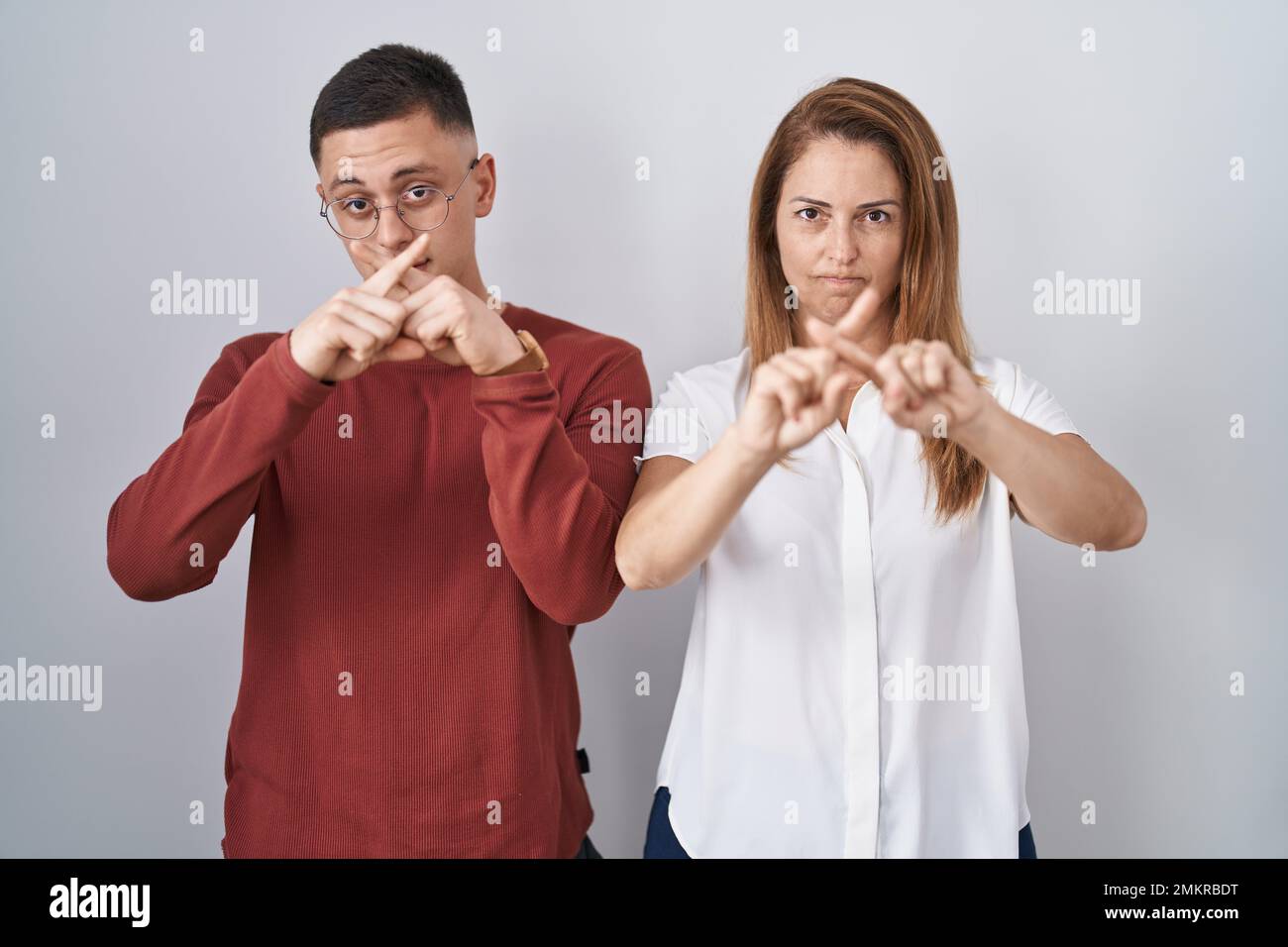 Mother and son standing together over isolated background rejection ...